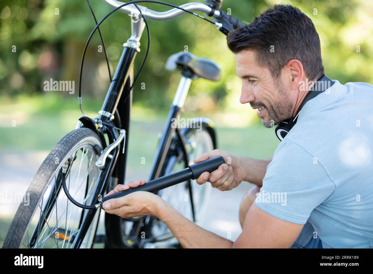 man pumps up the bike wheel outdoor Stock Photo - Alamy