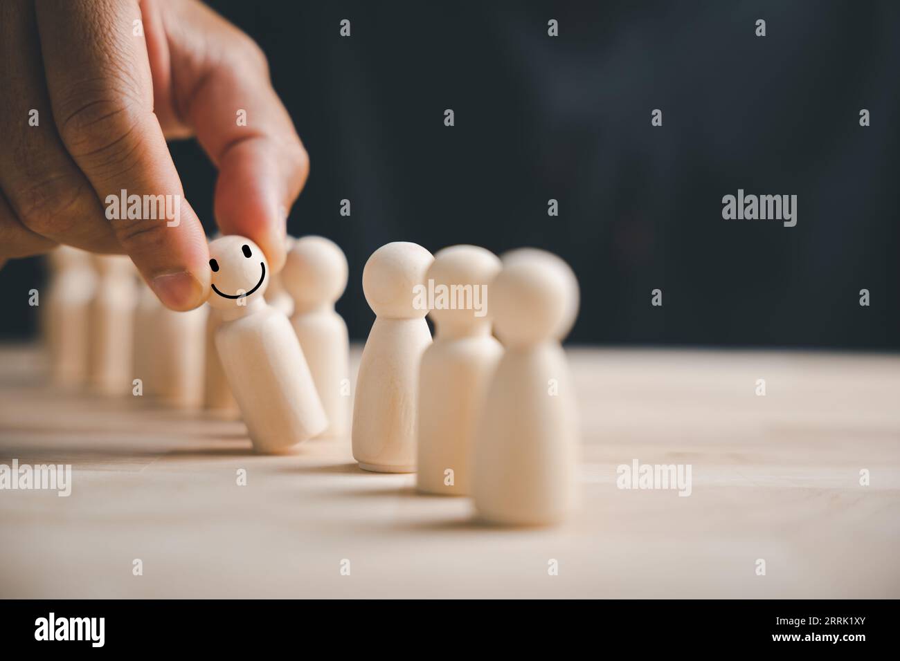 Hand choosing a wooden figure as the chosen leader from the crowd Stock ...