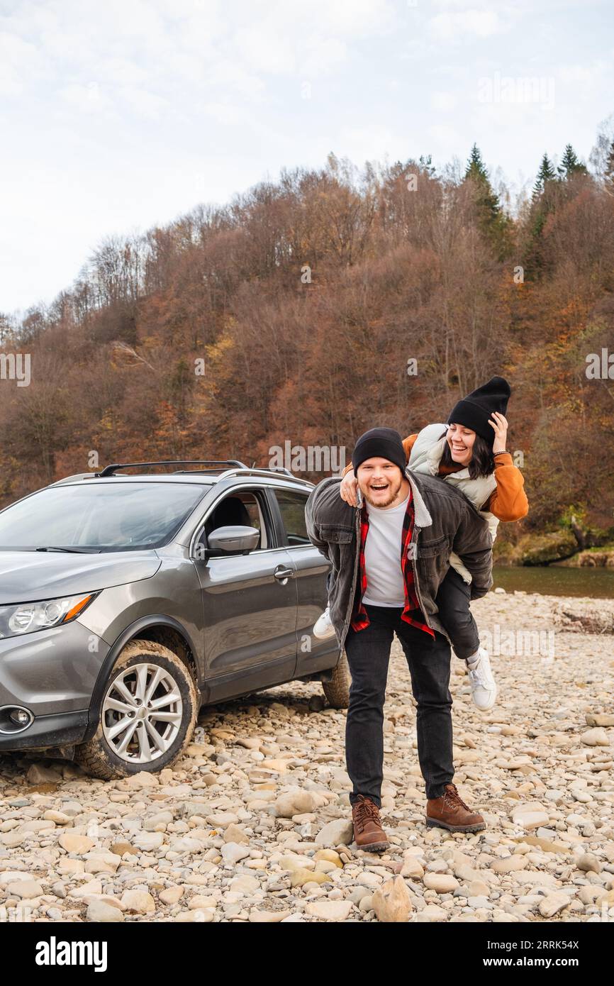 happy couple piggyback car at rocky mountain beach Stock Photo - Alamy