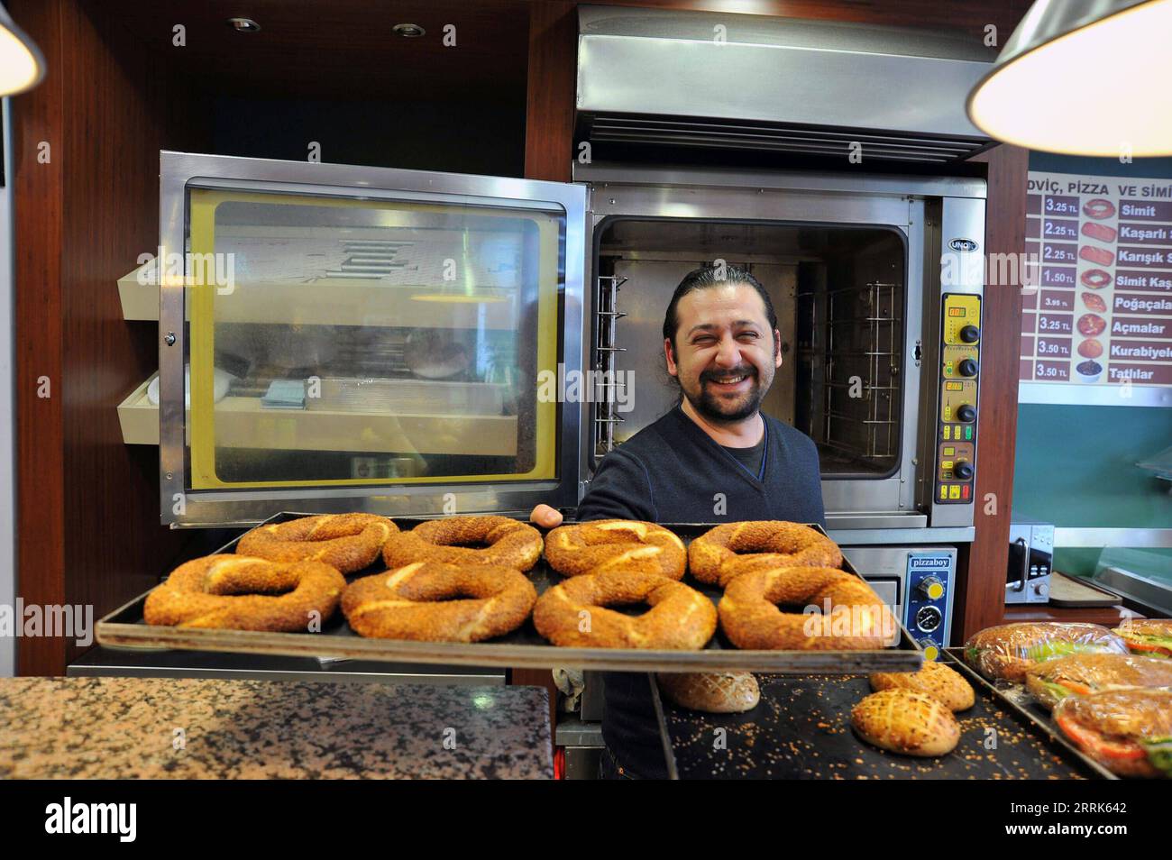 220820 -- ANKARA, Aug. 20, 2022 -- A bakery worker presents simits in ...