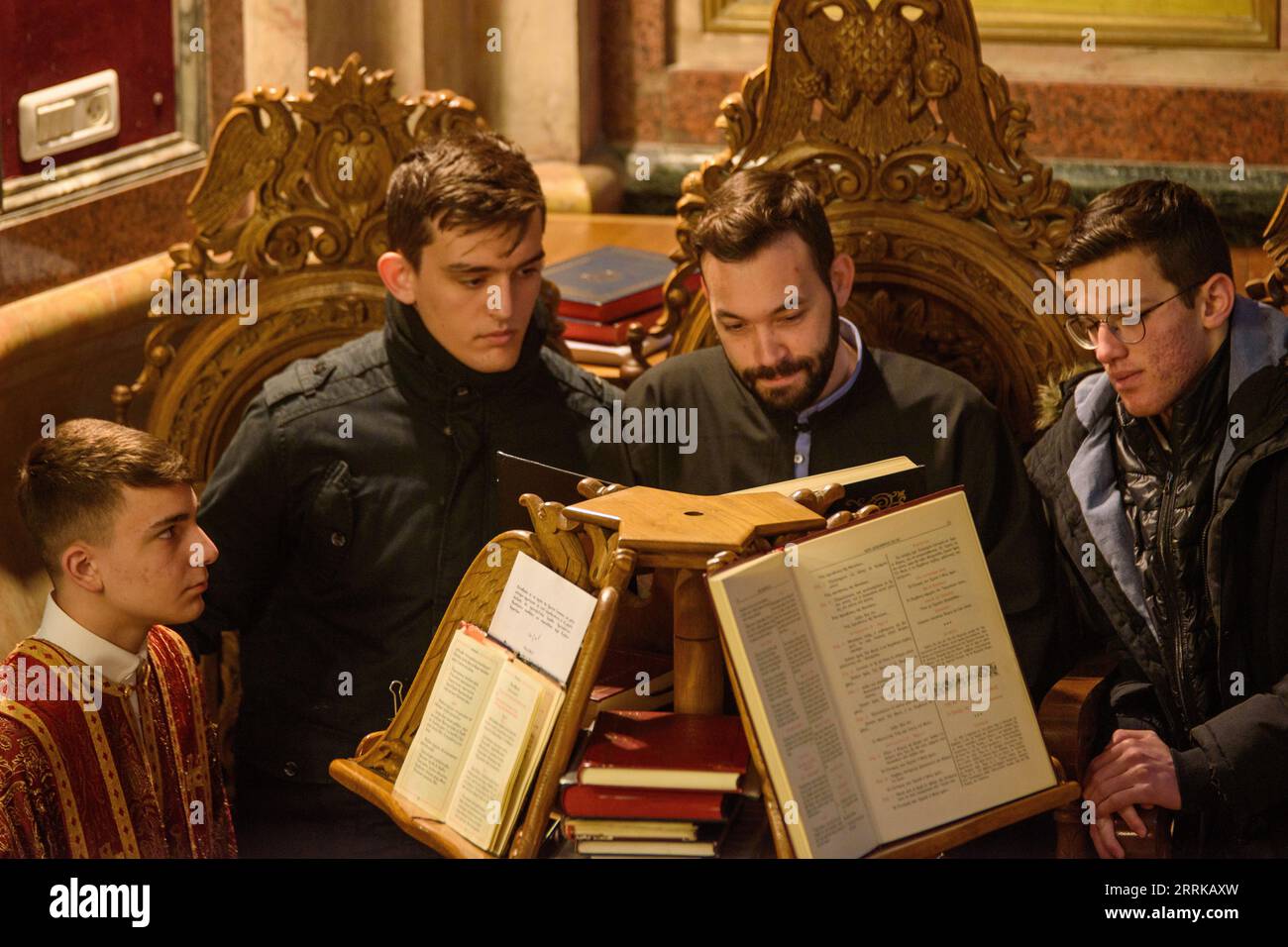 A group of men standing in a religious setting, admiring a bible held ...