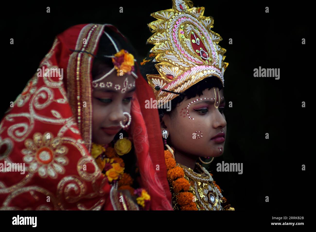 A young Hindu boy and girl, dressed as Lord Krishna and Radha, take ...