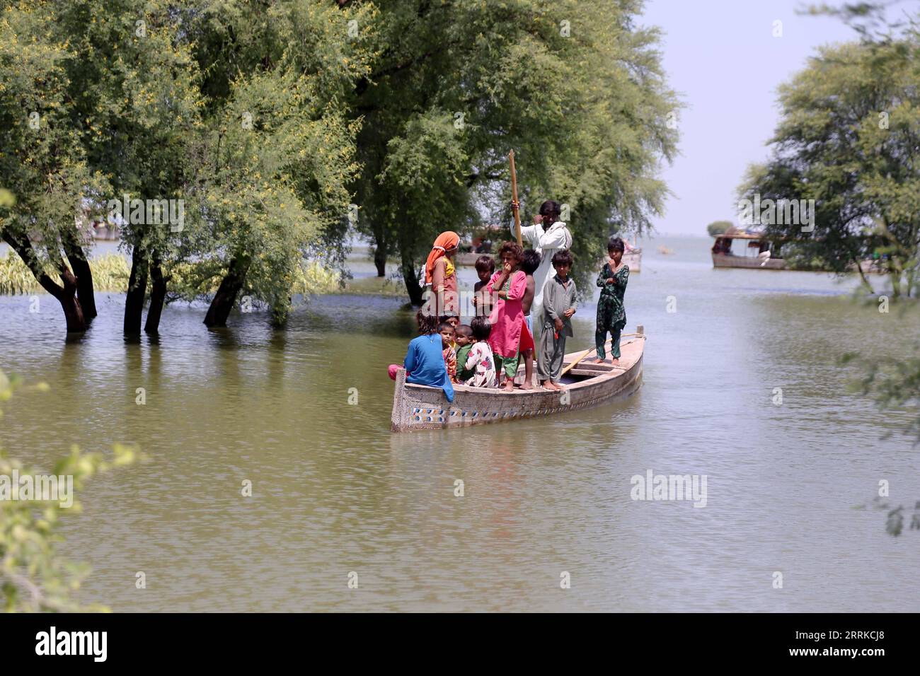 220902 -- DADU, Sept. 2, 2022 -- Flood-affected people travel on a boat ...