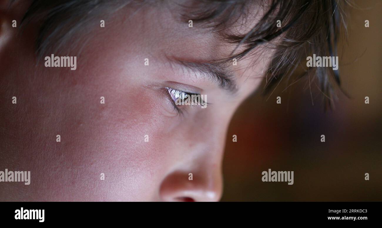 Boy eyes looking at device screen. Child staring at bright blue display ...