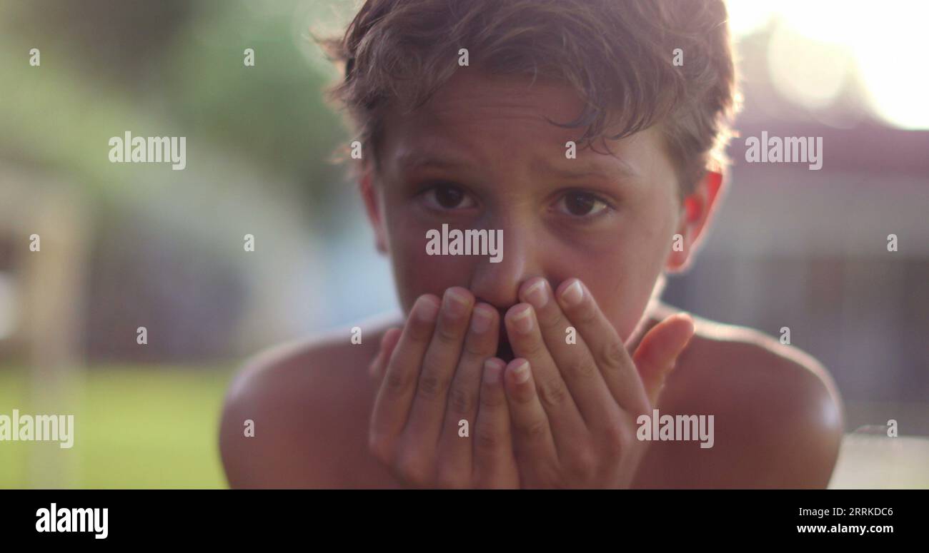 Boy covering face with hands feeling sad, child peeking from hands ...