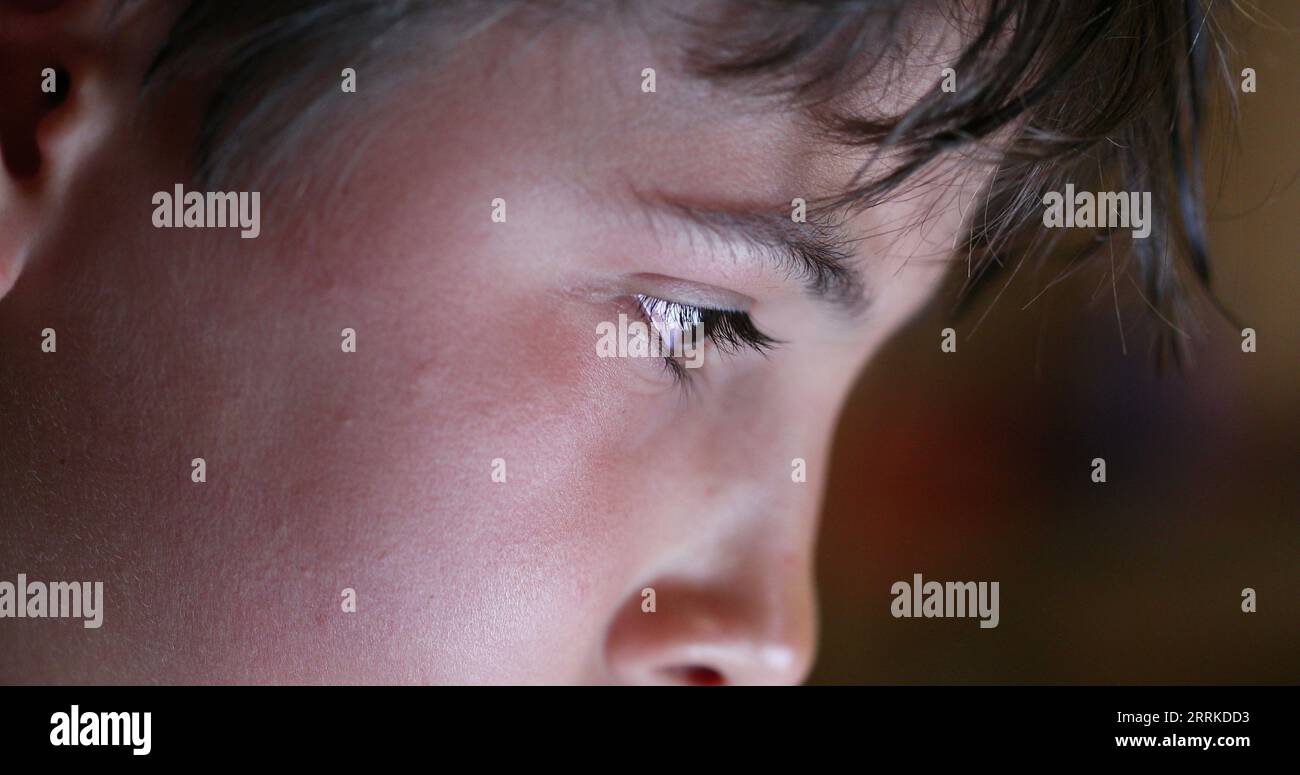 Boy eyes looking at device screen. Child staring at bright blue display ...