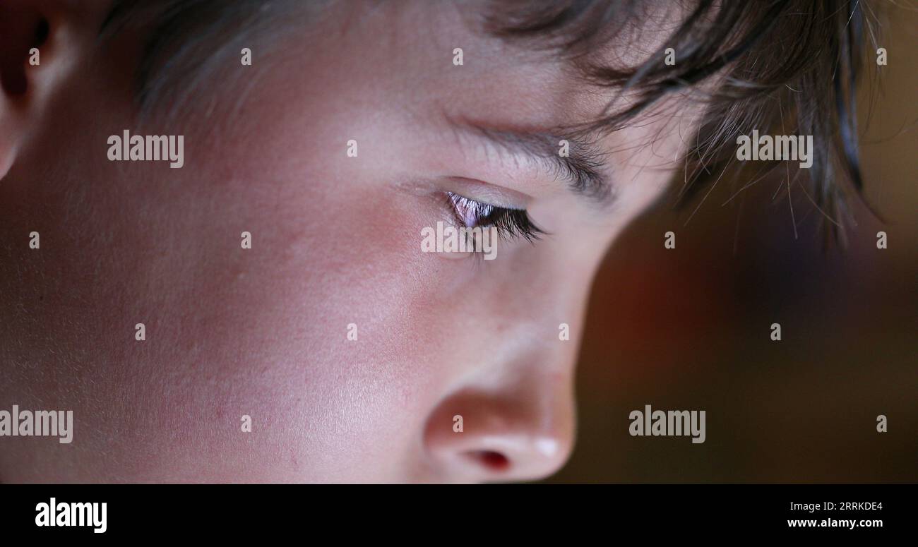 Boy eyes looking at device screen. Child staring at bright blue display ...