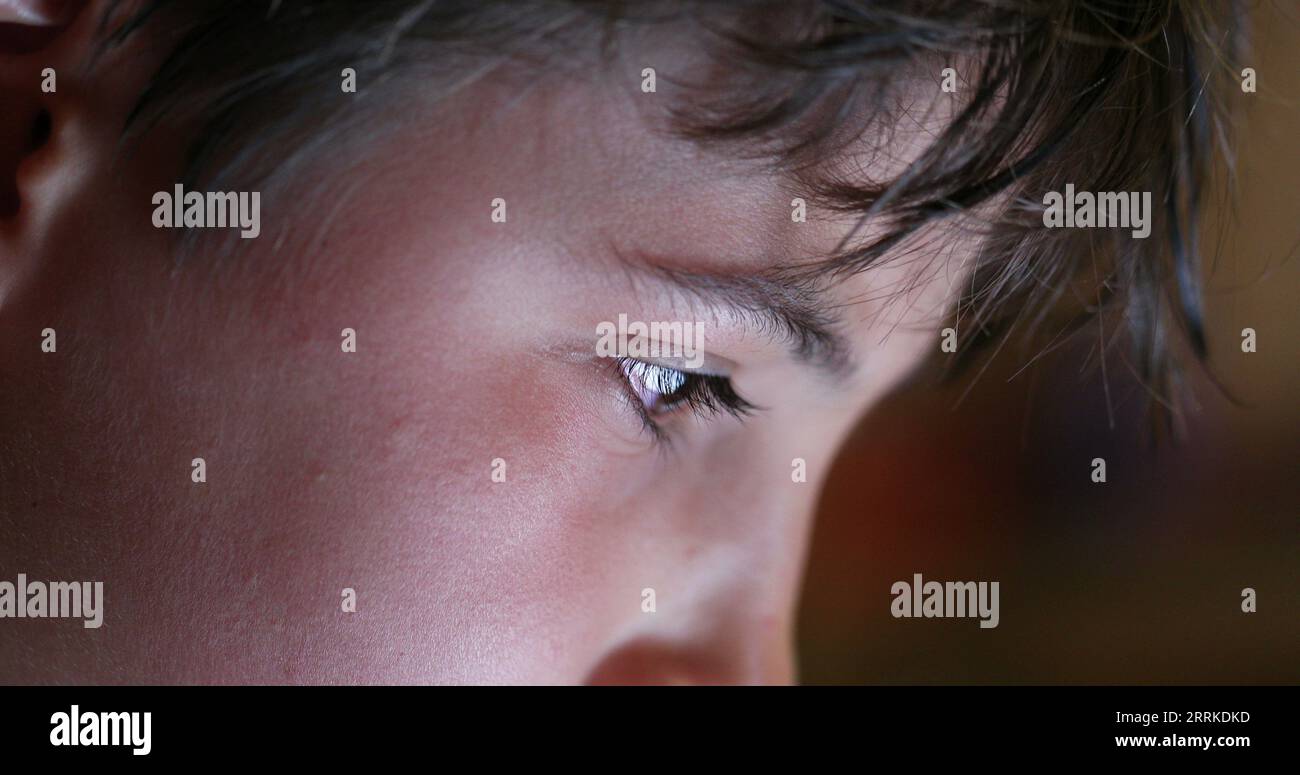 Boy eyes looking at device screen. Child staring at bright blue display ...
