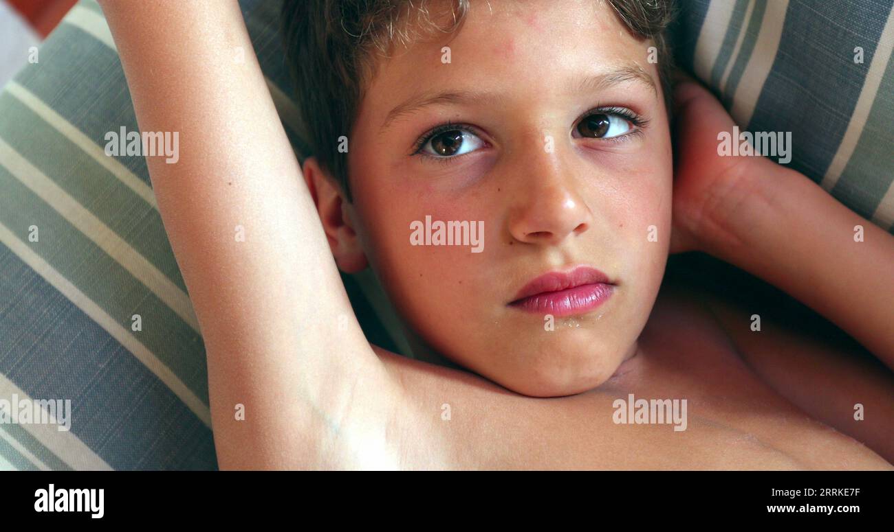 Bored child boy lying at sofa at home Stock Photo - Alamy