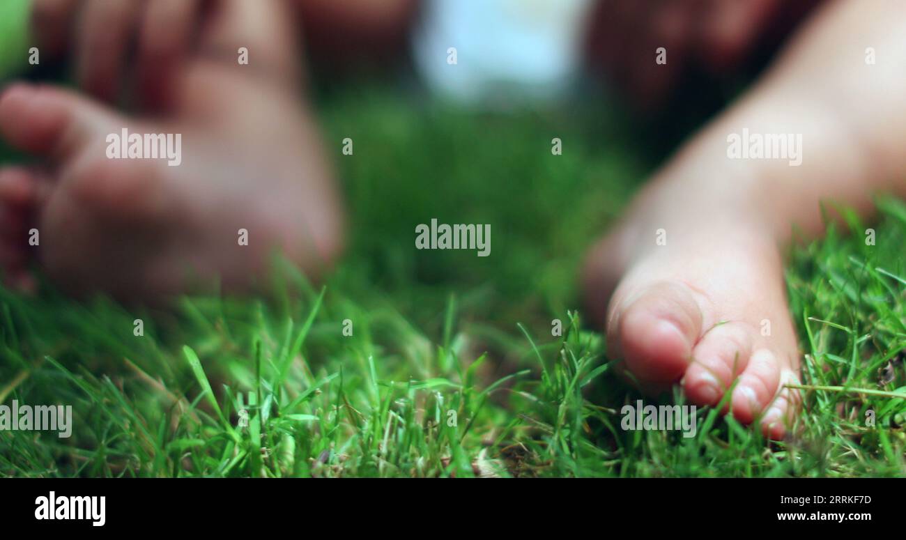 Baby infant toes and feet on grass outside in nature. Toddler legs ...