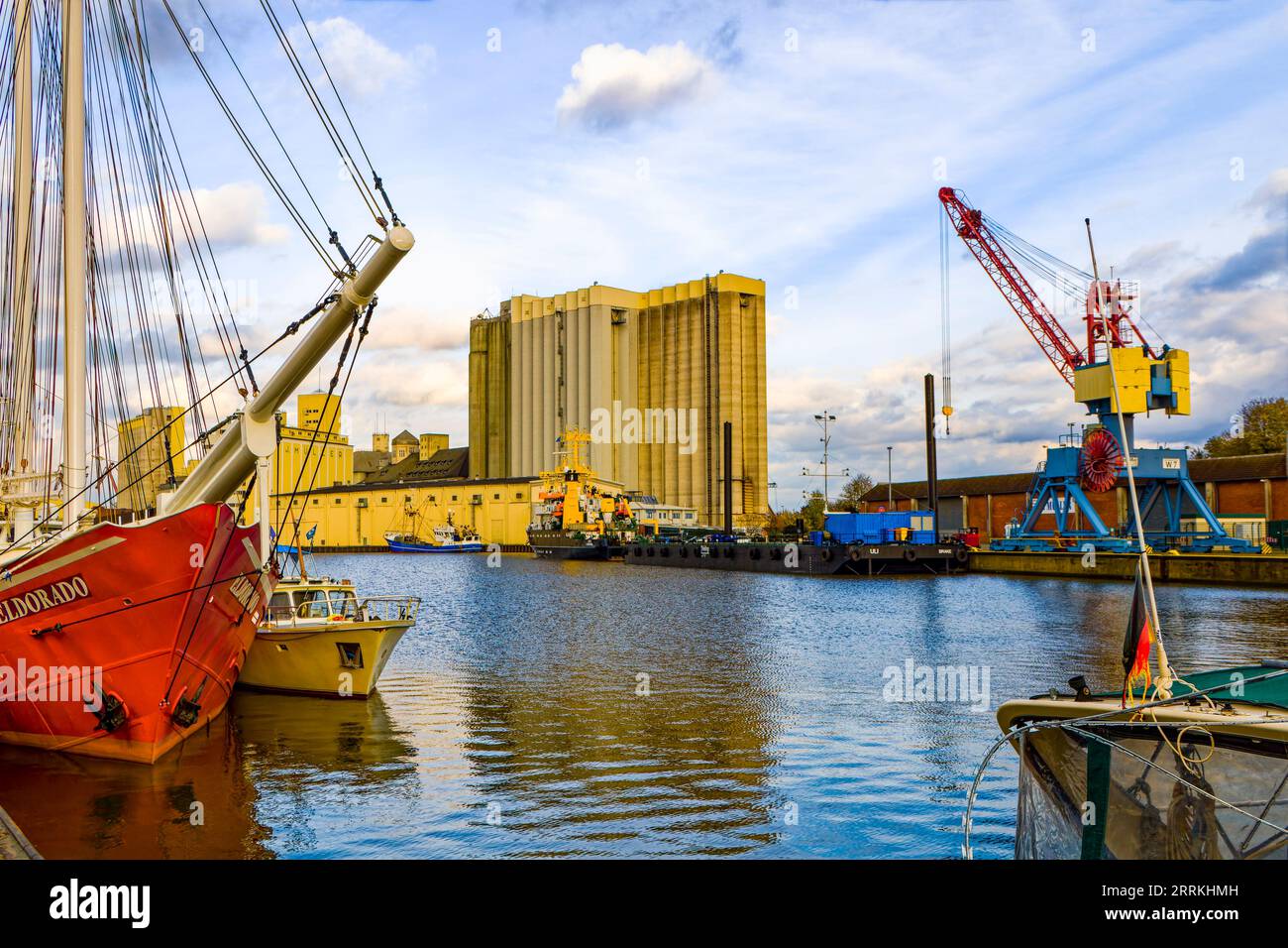 Port view with red tall ship, ships, storage facilities and crane Stock ...