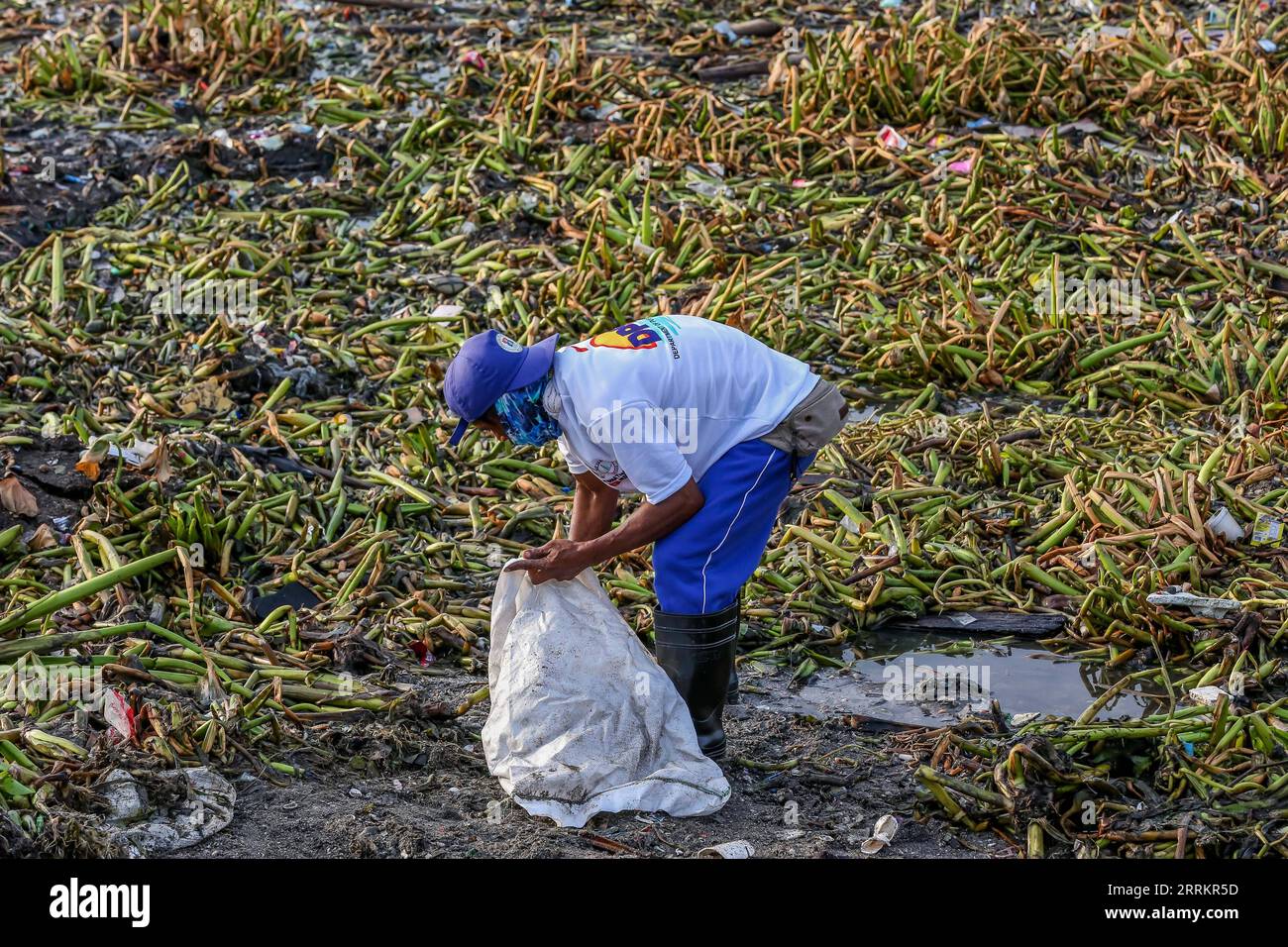 220917 -- MANILA, Sept. 17, 2022 -- A man collects rubbish along the ...