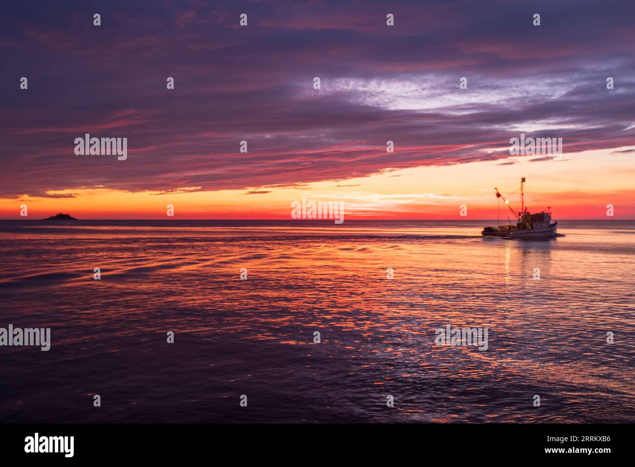 a boat in the sunset in shades of pink and violet Stock Photo - Alamy
