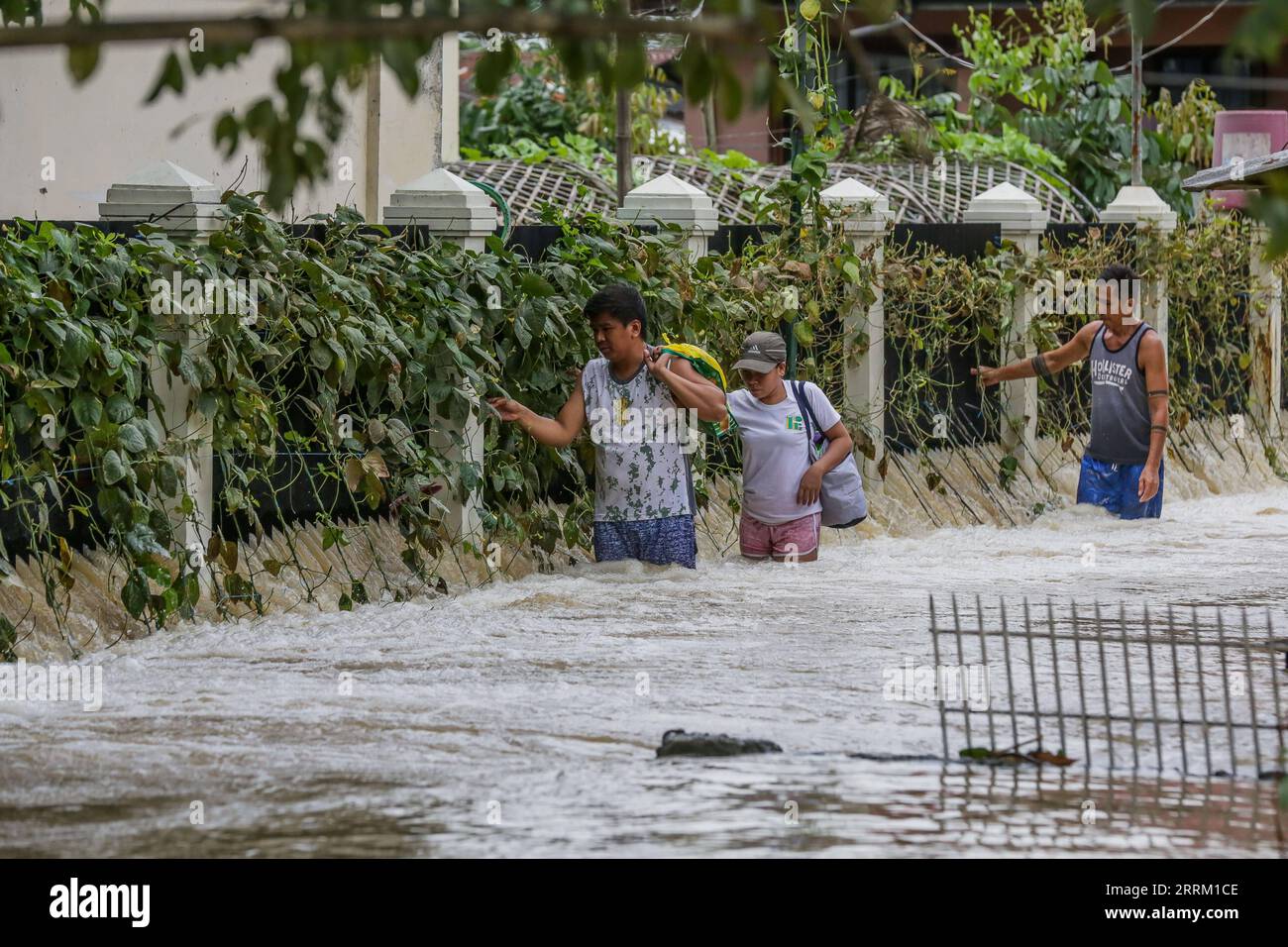 220926 -- BULACAN, Sept. 26, 2022 -- Residents wade through a flooded ...