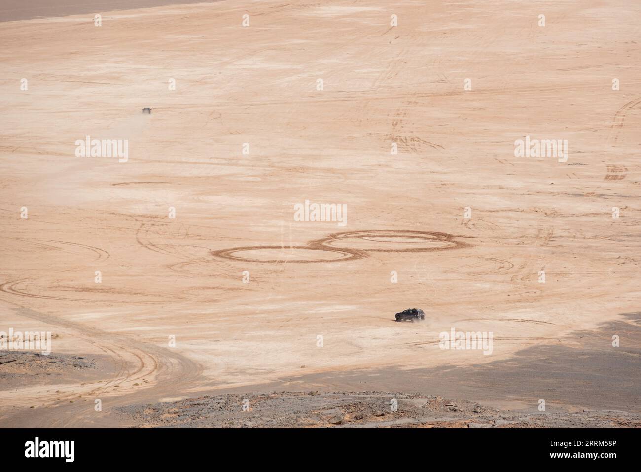 Round circles in the desert sand, an off-road vehicle passing by, near ...