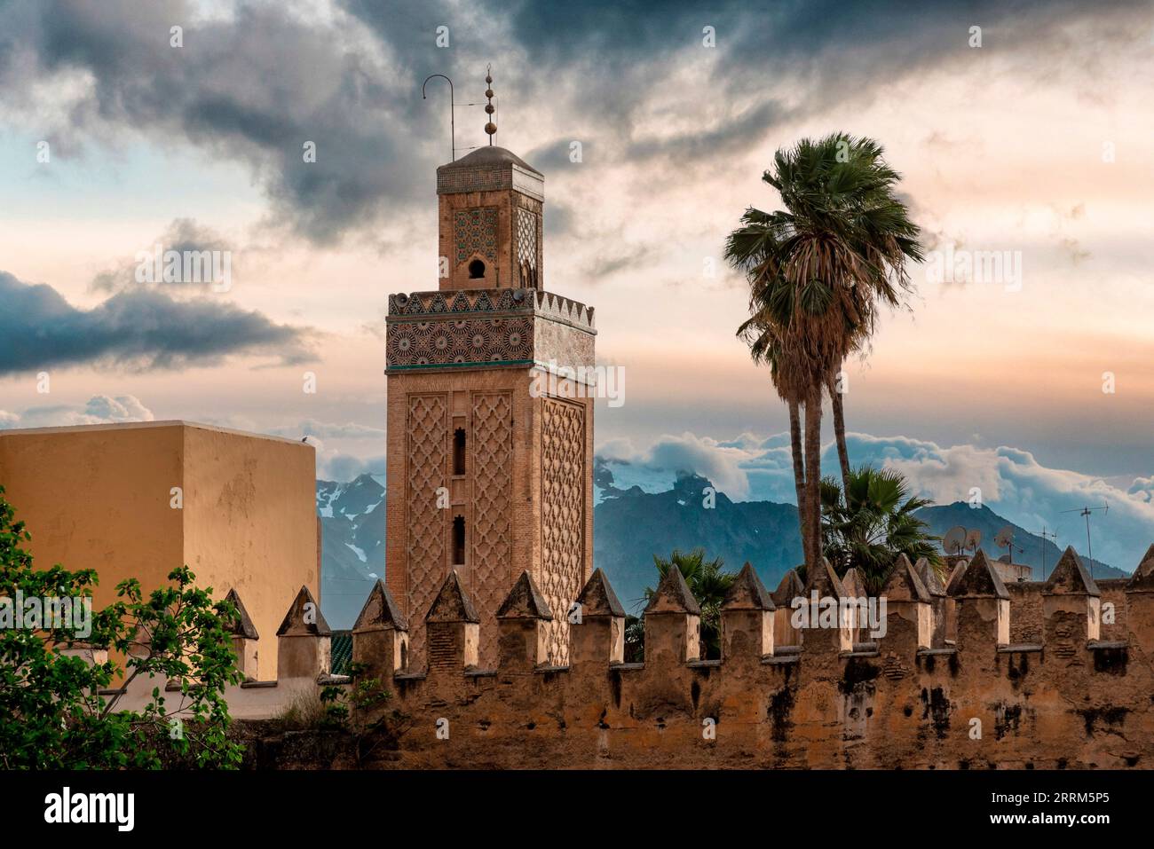 Minaret of an old mosque in Marrakech, Atlas mountains and a scenic sky ...