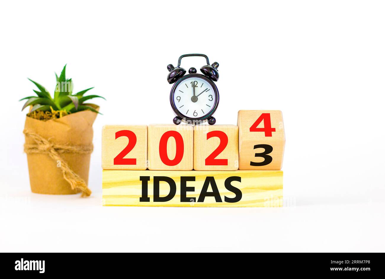 2024 ideas new year symbol. Businessman turns a wooden cube and changes words Ideas 2023 to ...
