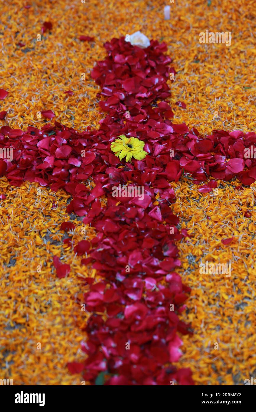 Cross made my red rose and marigold flower leaves Stock Photo - Alamy