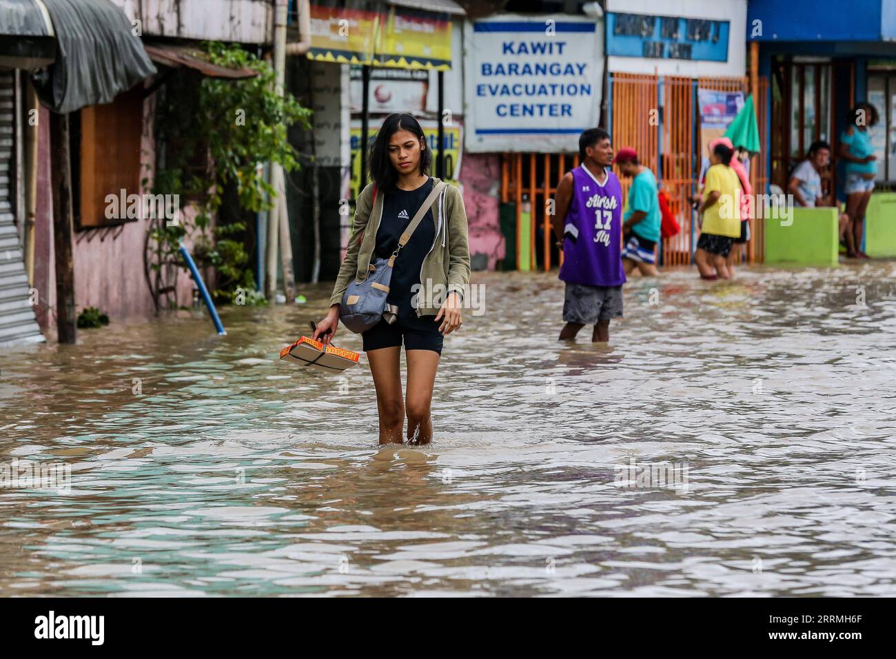221030 -- CAVITE PROVINCE, Oct. 30, 2022 -- Residents wade through the ...