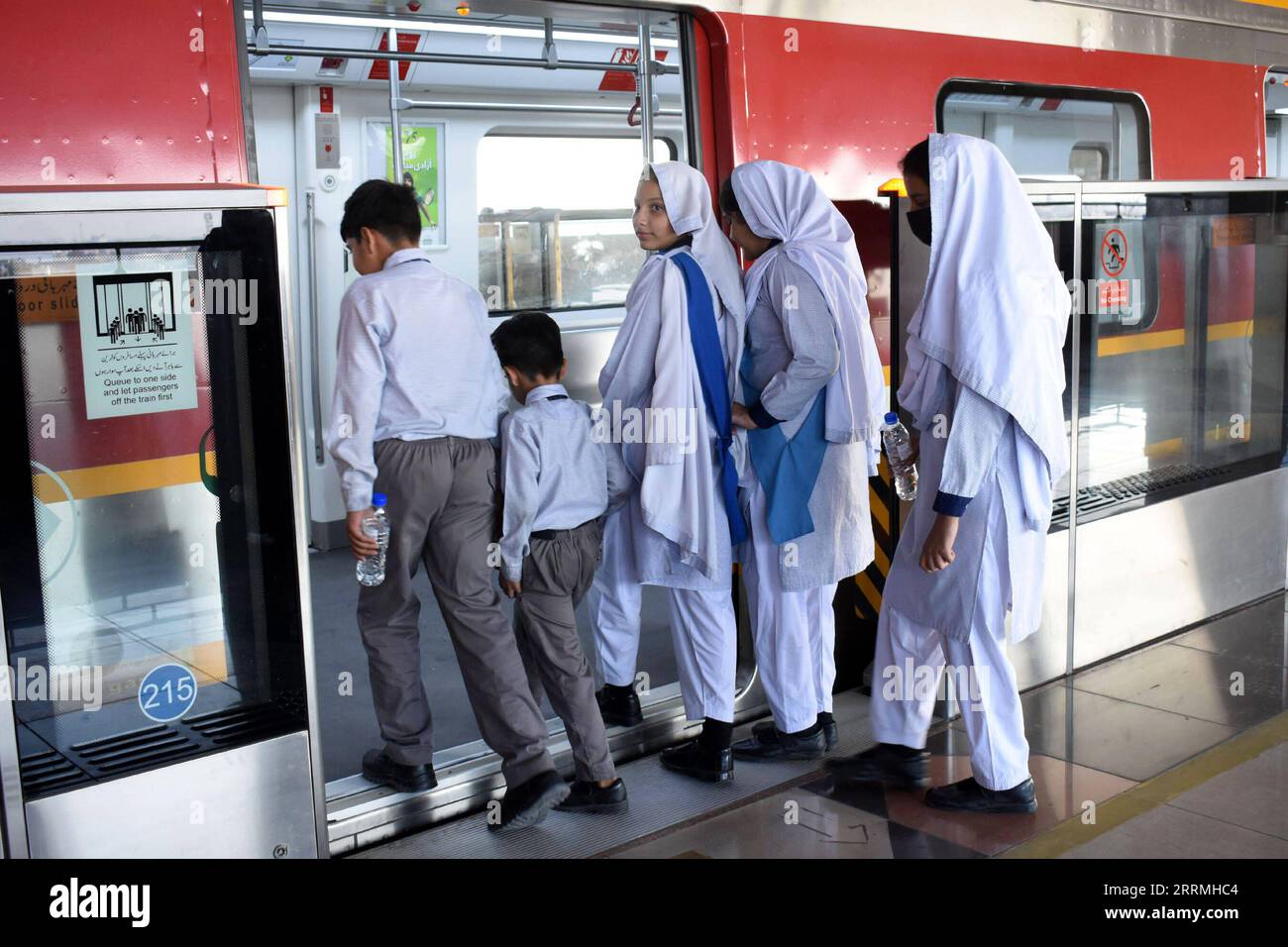 221031 -- LAHORE, Oct. 31, 2022 -- Students board an Orange Line Metro ...