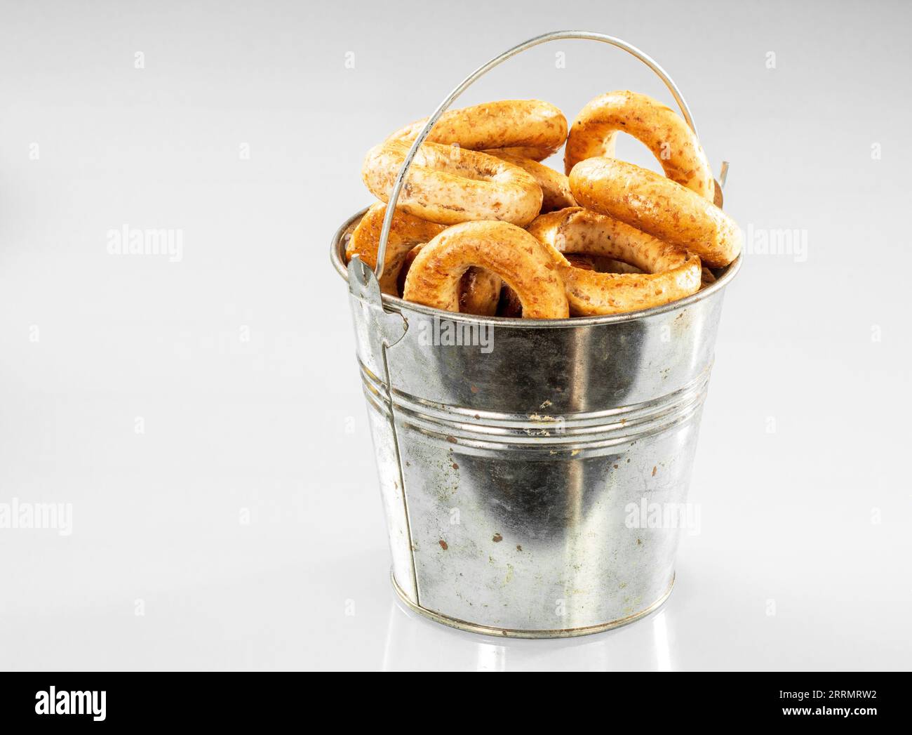Old metal kitchen bucket with crispy bagels on a white background Stock ...