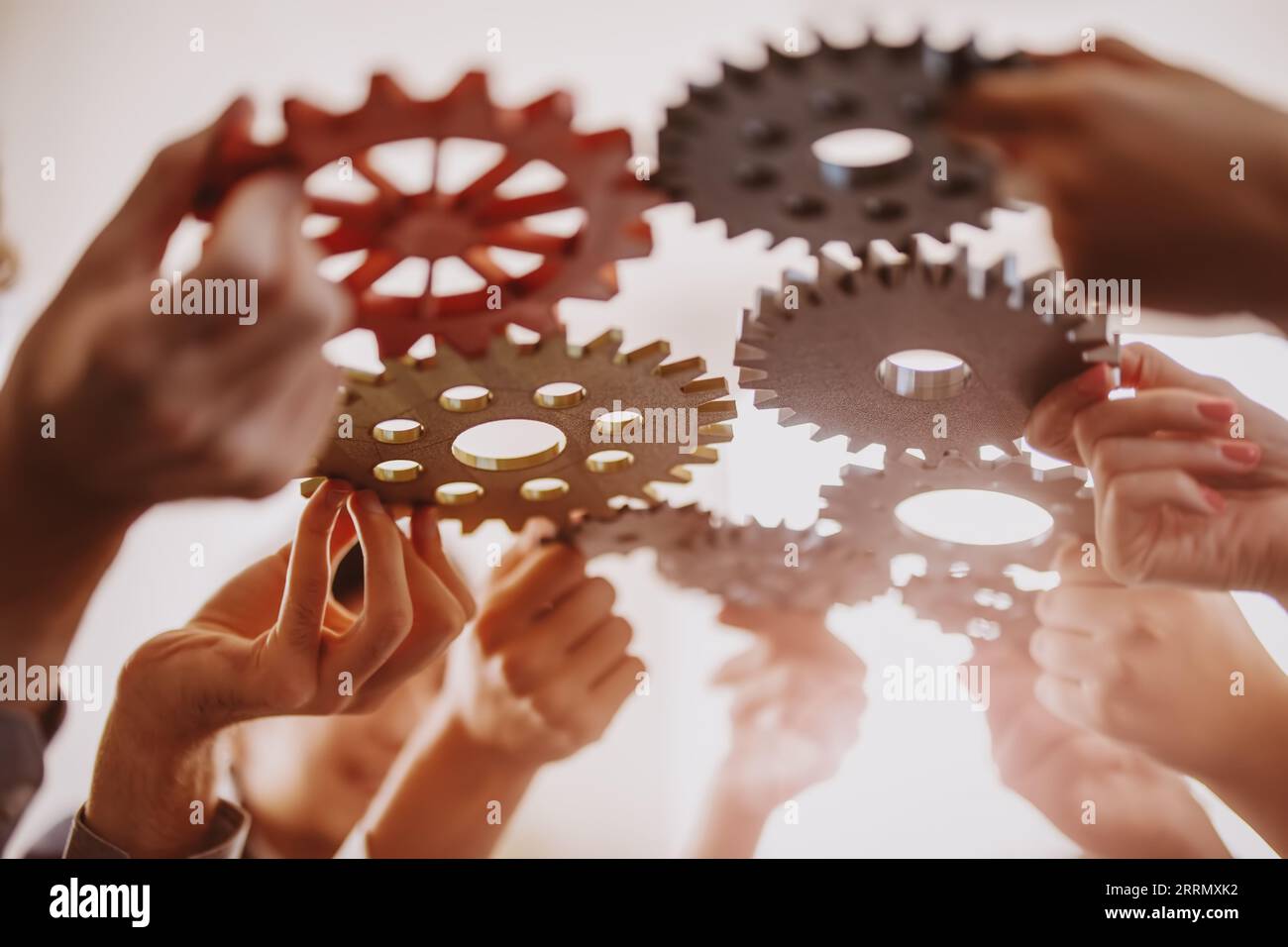 People's hands joining different metall cog wheel together Stock Photo ...