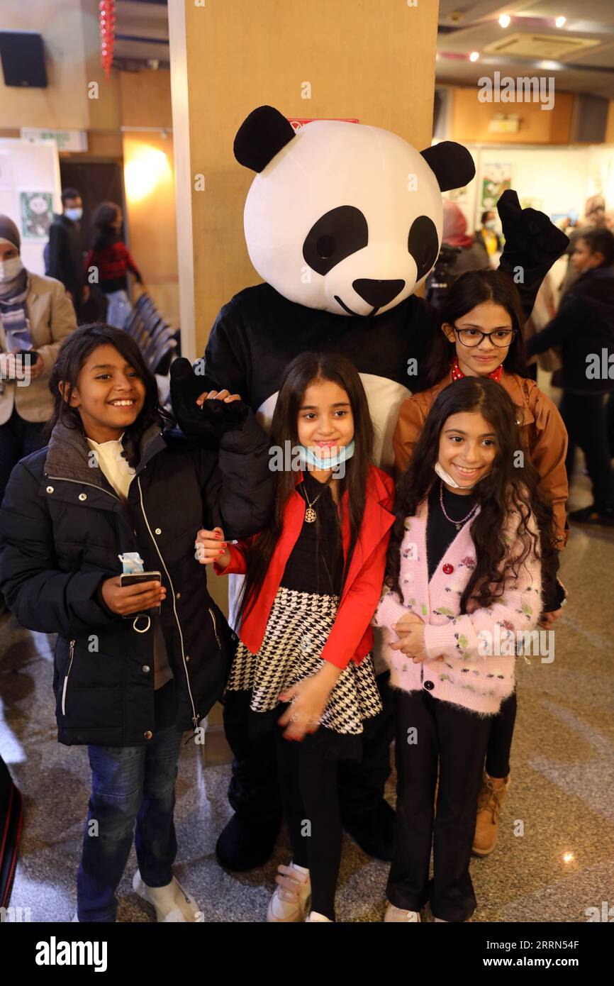 221211 -- CAIRO, Dec. 11, 2022 -- Students pose for photos with a staff member dressed as a ...