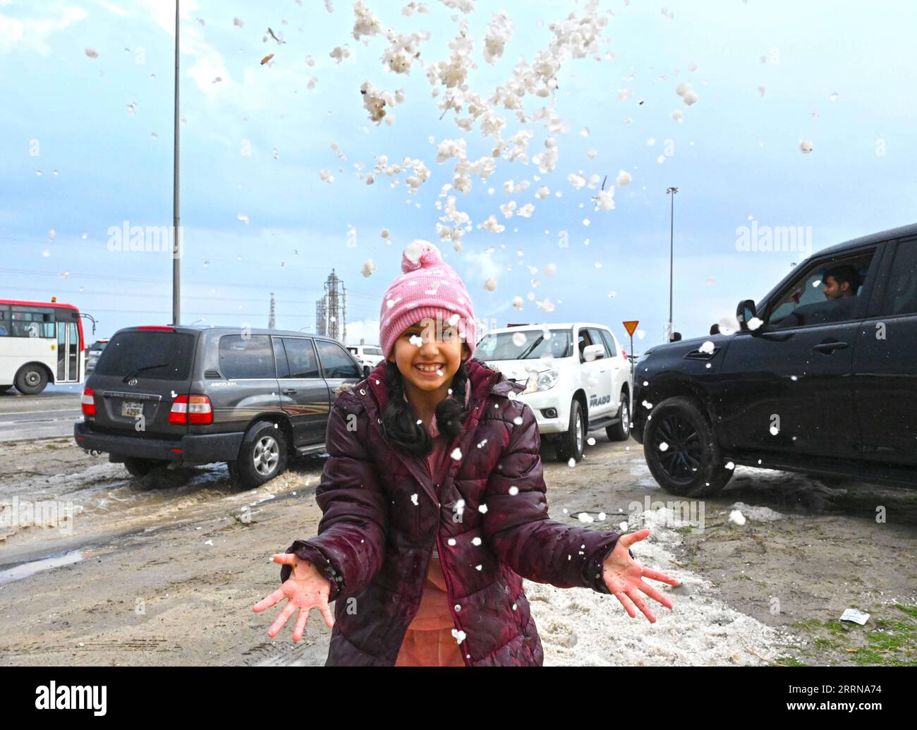 221227 -- AHMADI KUWAIT, Dec. 27, 2022 -- A girl plays with hailstones ...