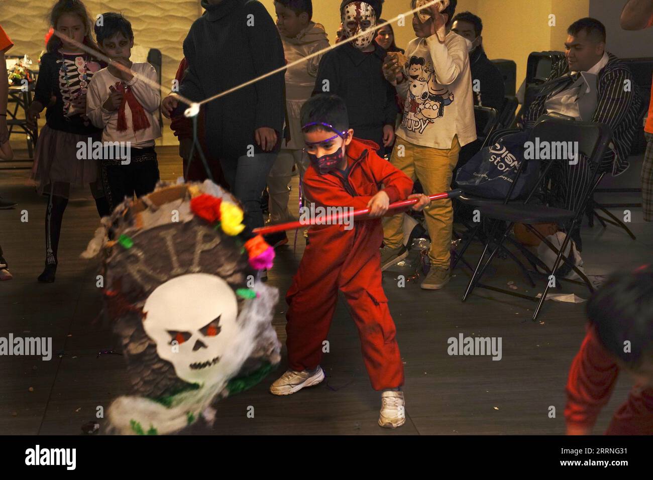 FILE - A child strikes a piñata during a Day of the Dead celebration in ...