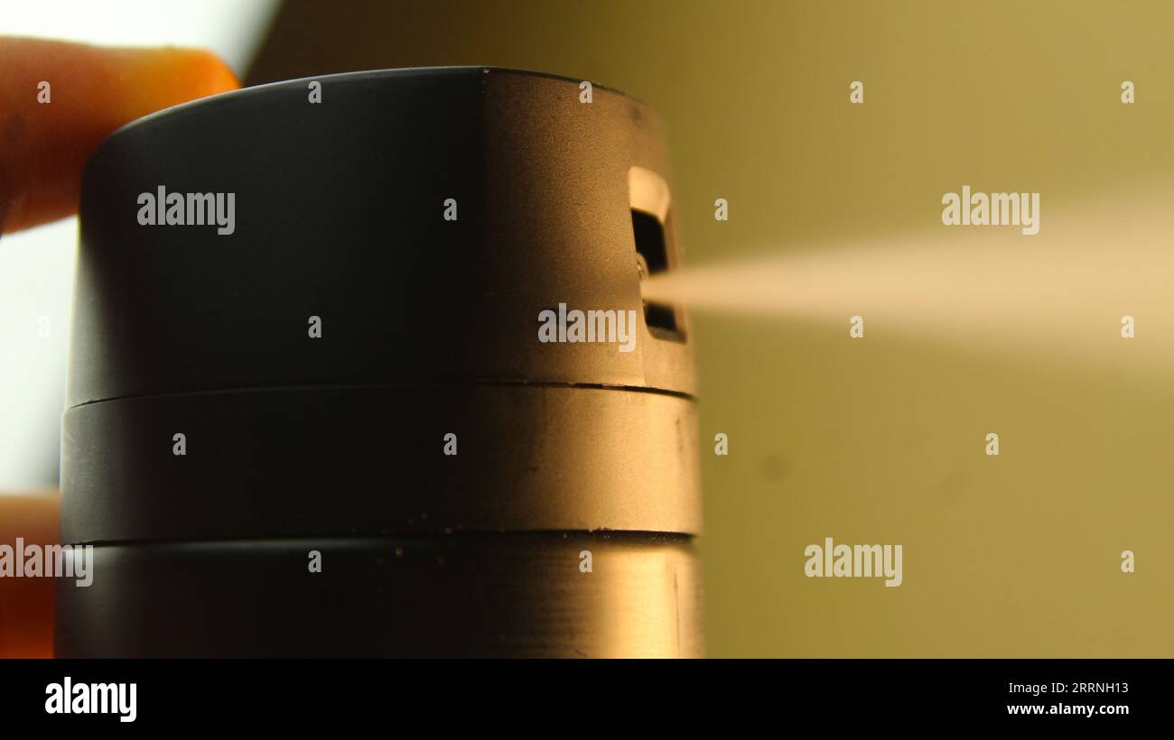 Someone spraying deodorant out of black deodorant can Stock Photo - Alamy