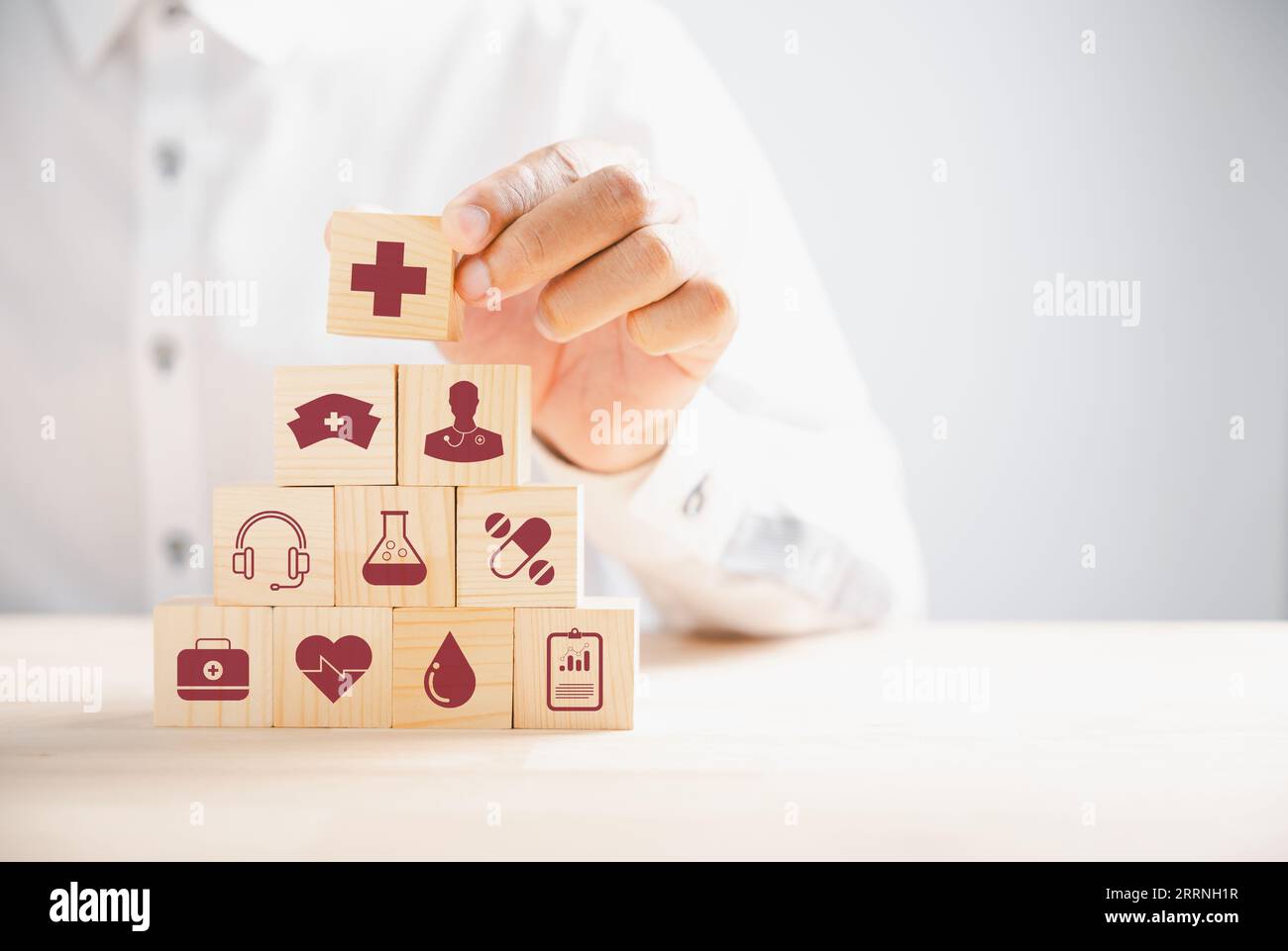 Hand hold wooden block with icon healthcare medical Stock Photo - Alamy