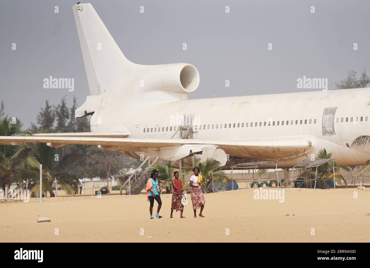230113 -- COTONOU, Jan. 13, 2023 -- Women take a walk on the beach in ...