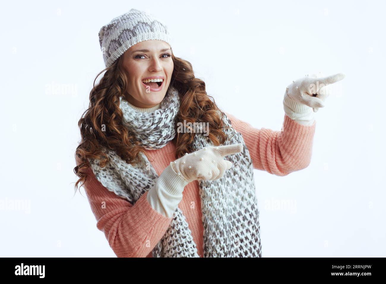 Hello winter. smiling modern female in sweater, mittens, hat and scarf ...