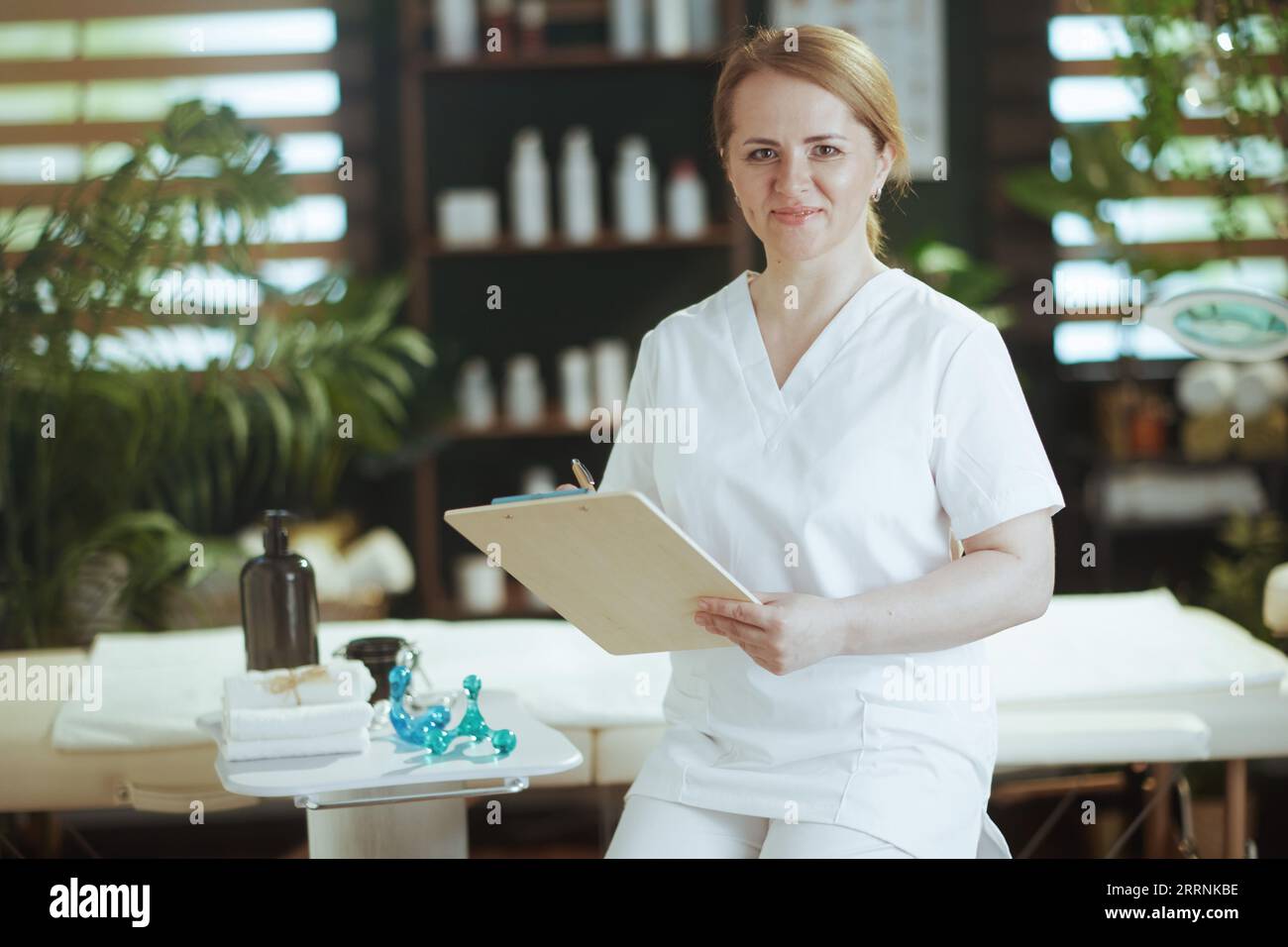 Healthcare time. female massage therapist in spa salon with clipboard Stock Photo - Alamy