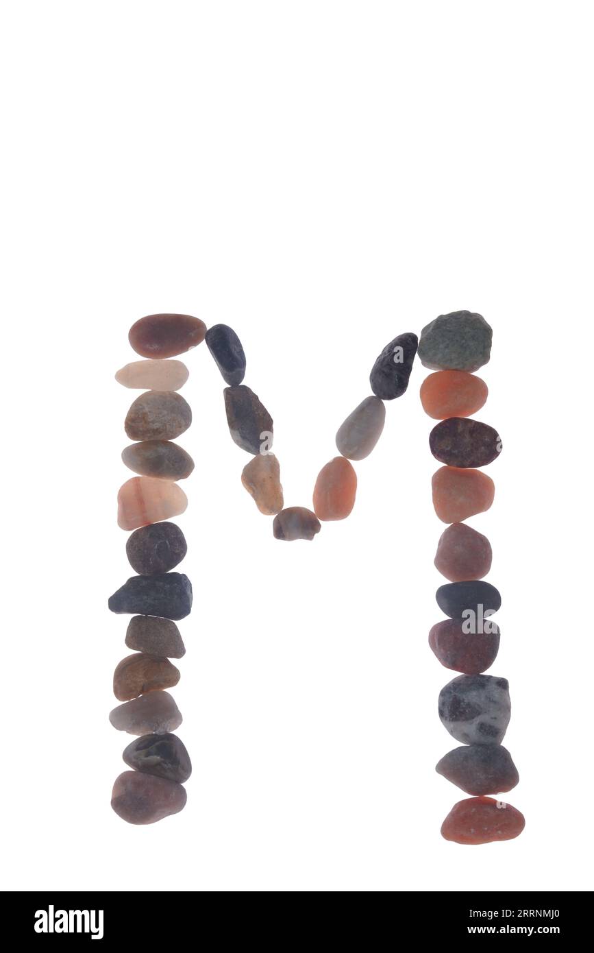 Letter M handcrafted using small stones or pebbles, single object ...