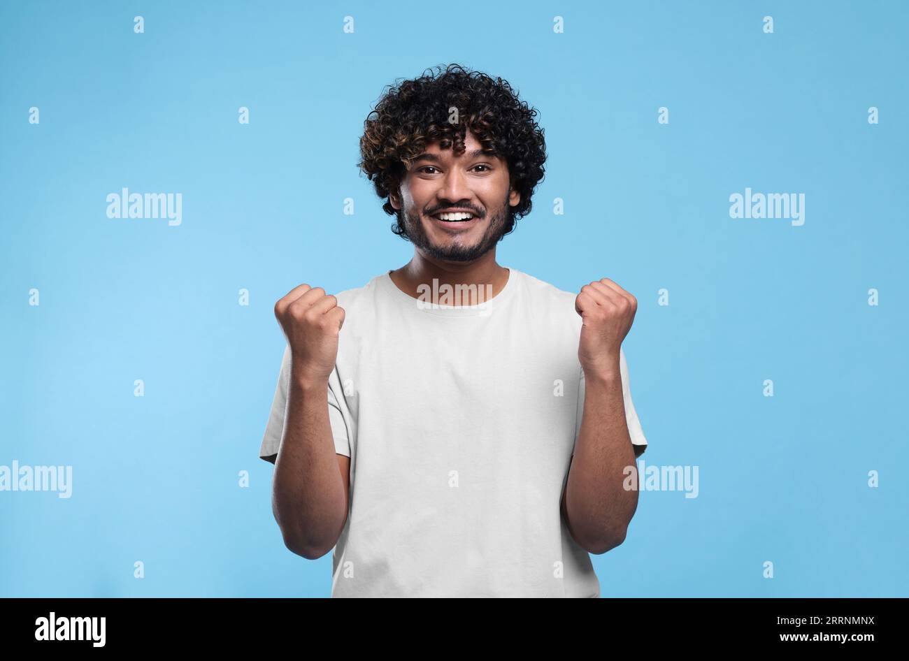 Handsome happy man on light blue background Stock Photo - Alamy