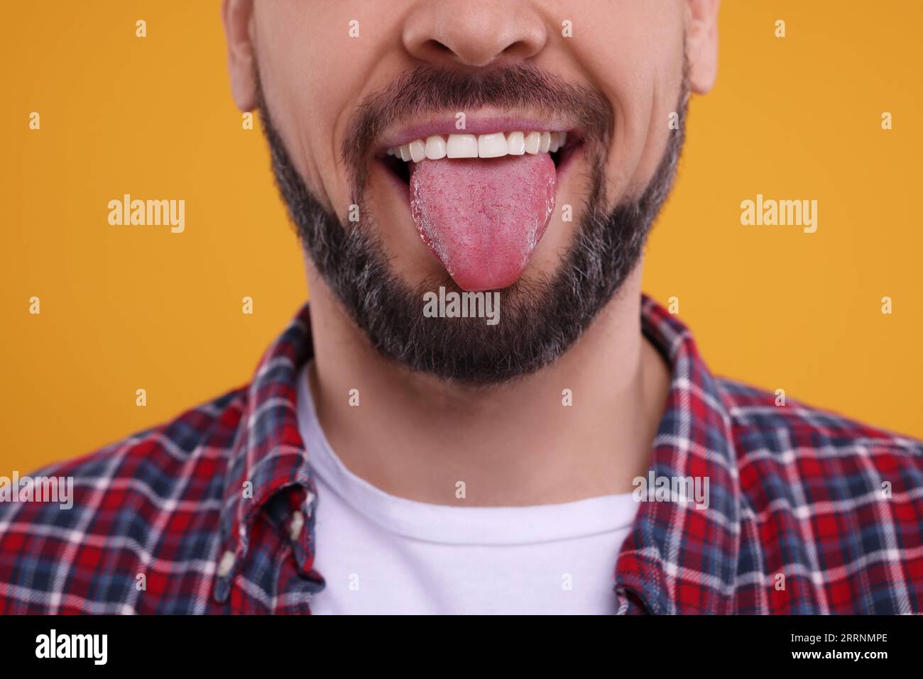 Happy man showing his tongue on orange background, closeup Stock Photo ...