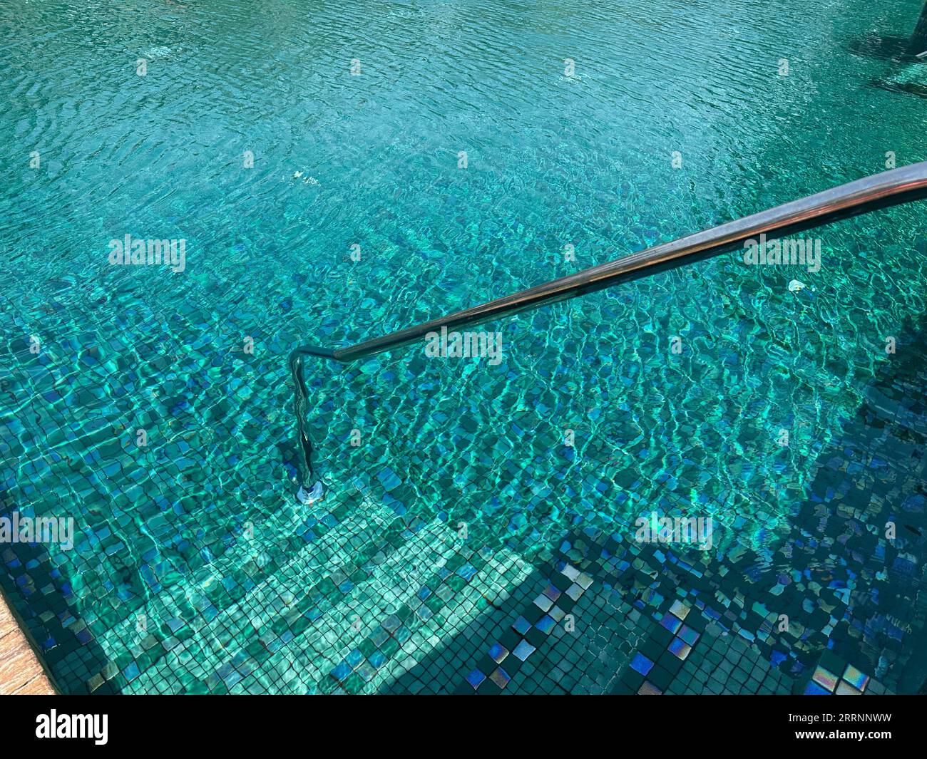 Metal rail and steps in outdoor swimming pool Stock Photo - Alamy
