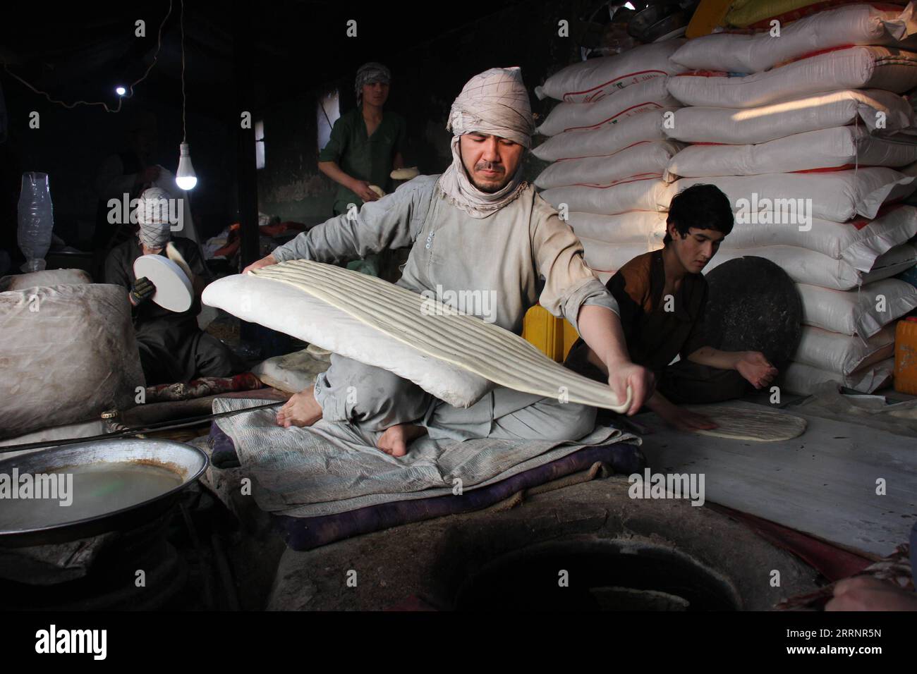 230126 -- BALKH, Jan. 26, 2023 -- People make naan a kind of Afghan ...
