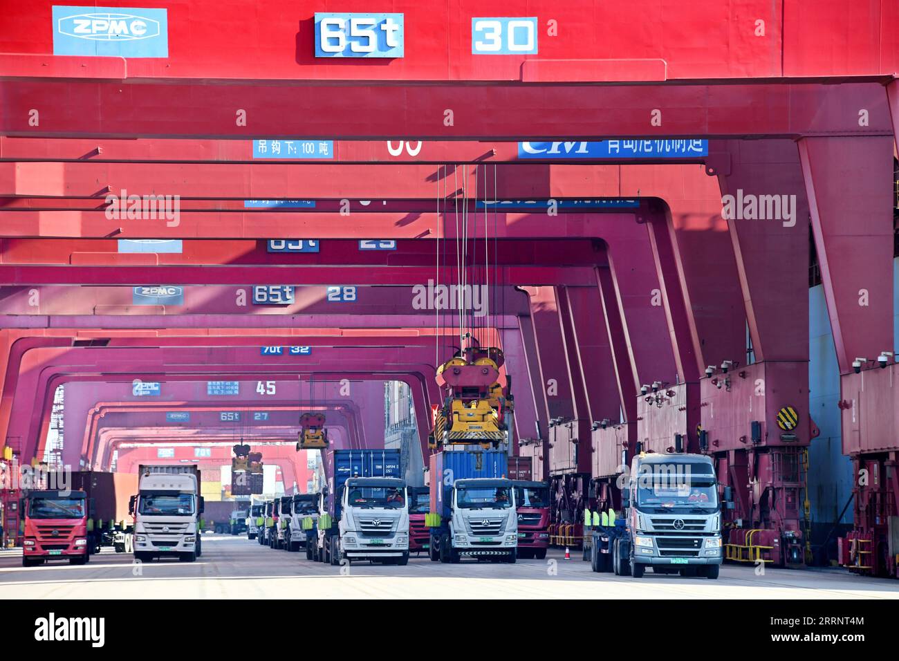 230128 -- QINGDAO, Jan. 28, 2023 -- Trucks transport containers at ...