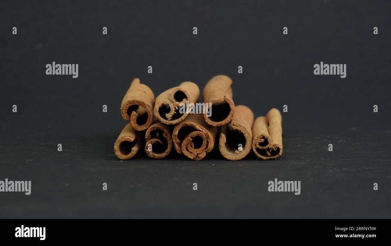 Fragrant cinnamon sticks isolated on dark background Stock Photo - Alamy