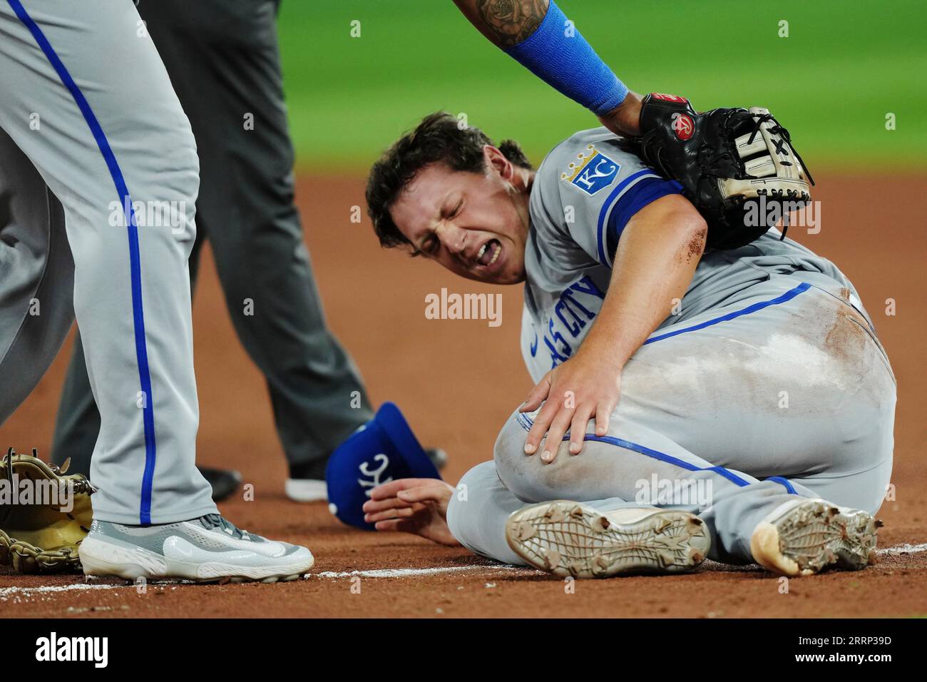 Kansas City Royals relief pitcher Austin Cox winces after an injury ...