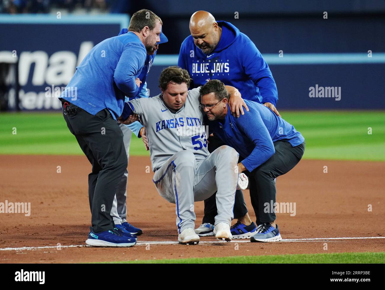 Kansas City Royals relief pitcher Austin Cox is helped off the field by ...