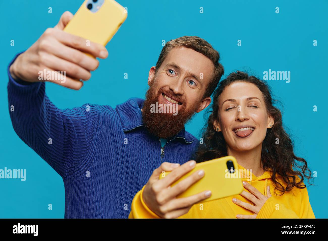 Woman and man funny couple with phones in hand taking selfies crooked ...