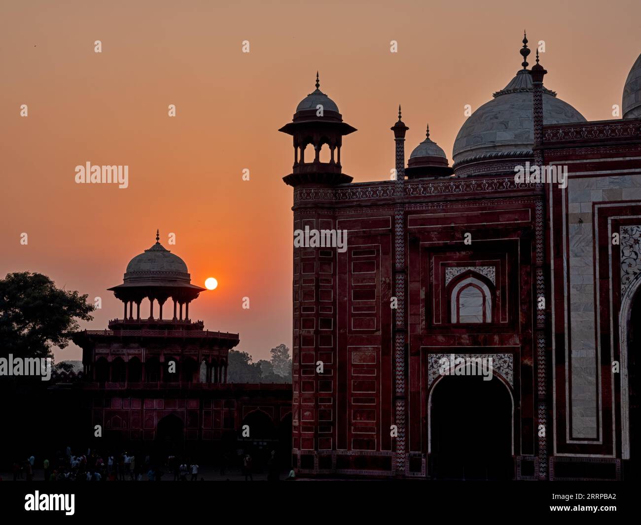 The mosque at the Taj Mahal at sunset is positioned in front of golden ...