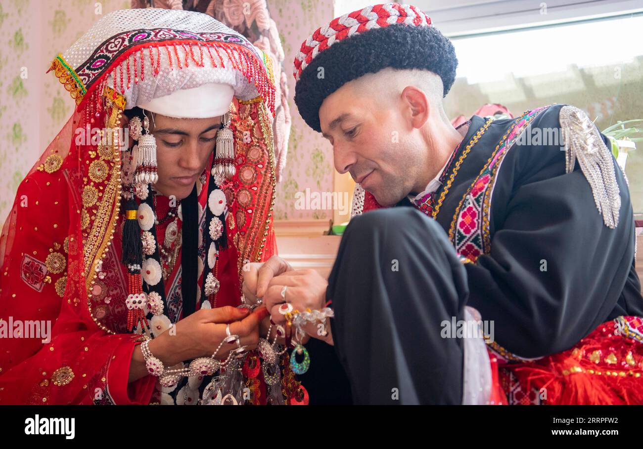 230322 -- TAXKORGAN, March 22, 2023 -- Mairmaitih Tirmur helps his ...