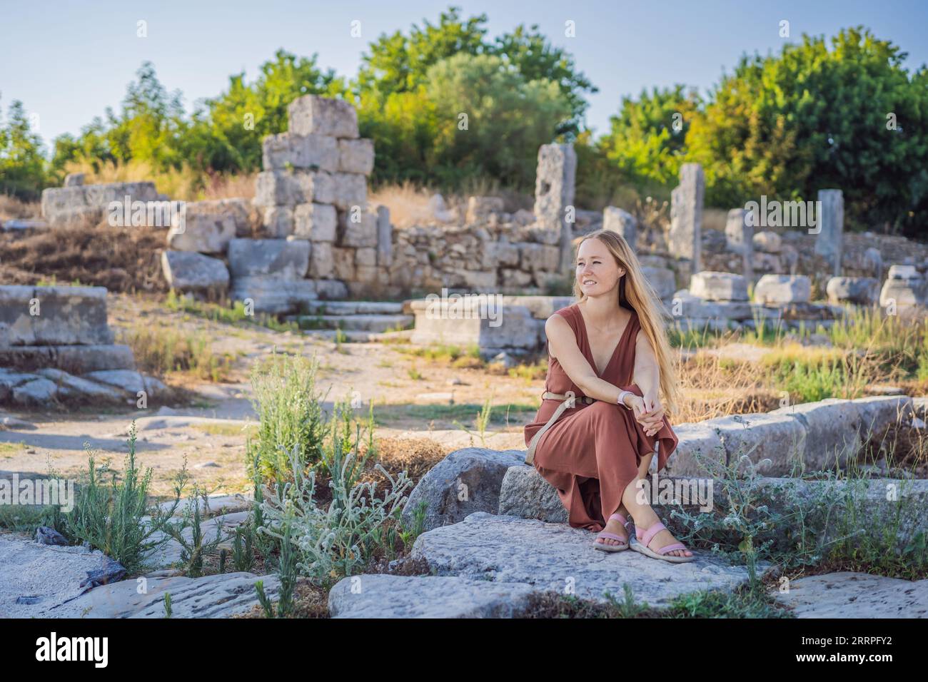 Pretty tourist woman at the ruins of ancient city of Perge near Antalya ...
