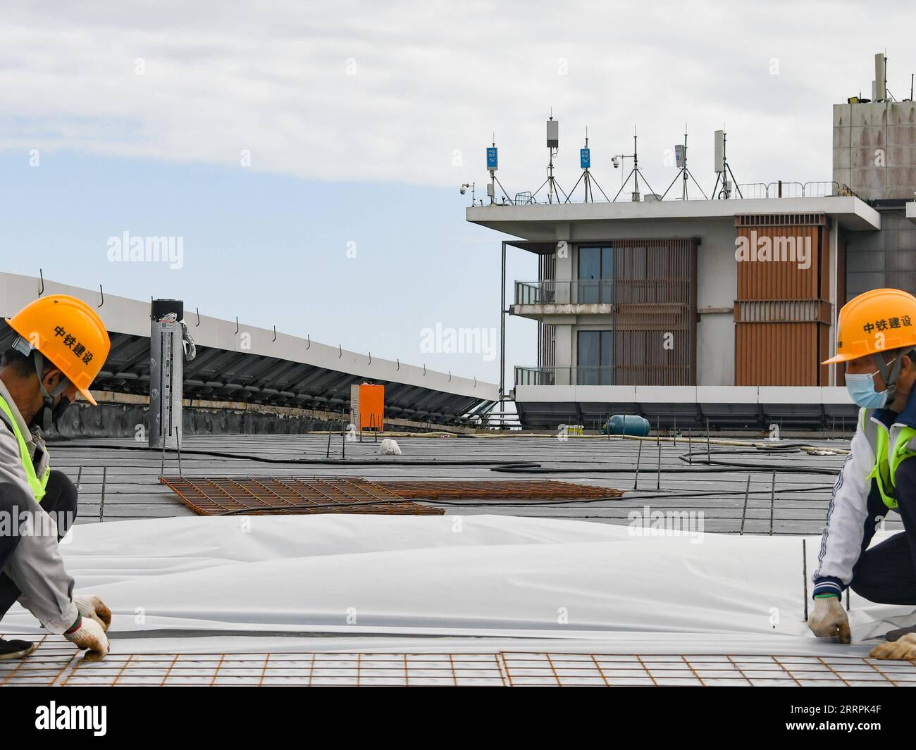 230328 -- BOAO, March 28, 2023 -- Workers perform tasks at a building ...