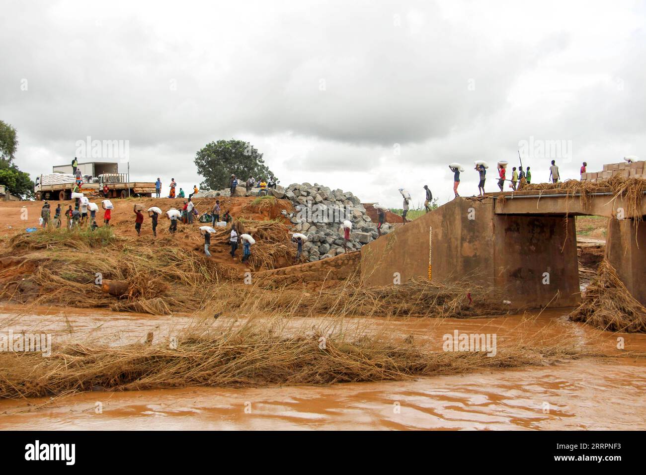 230404 -- CHIRADZULU, April 4, 2023 -- People carry goods across a ...