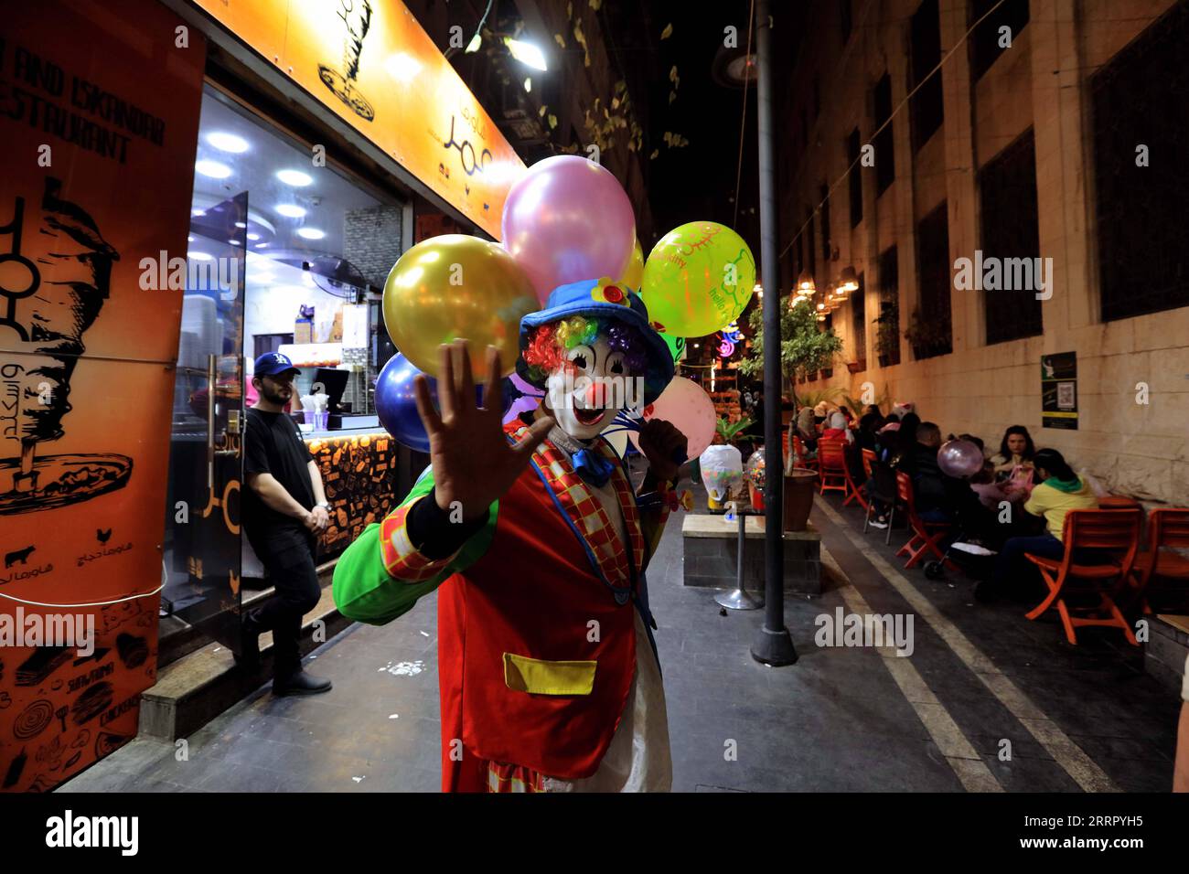 230419 -- AMMAN, April 19, 2023 -- A vendor dressed as a clown poses ...